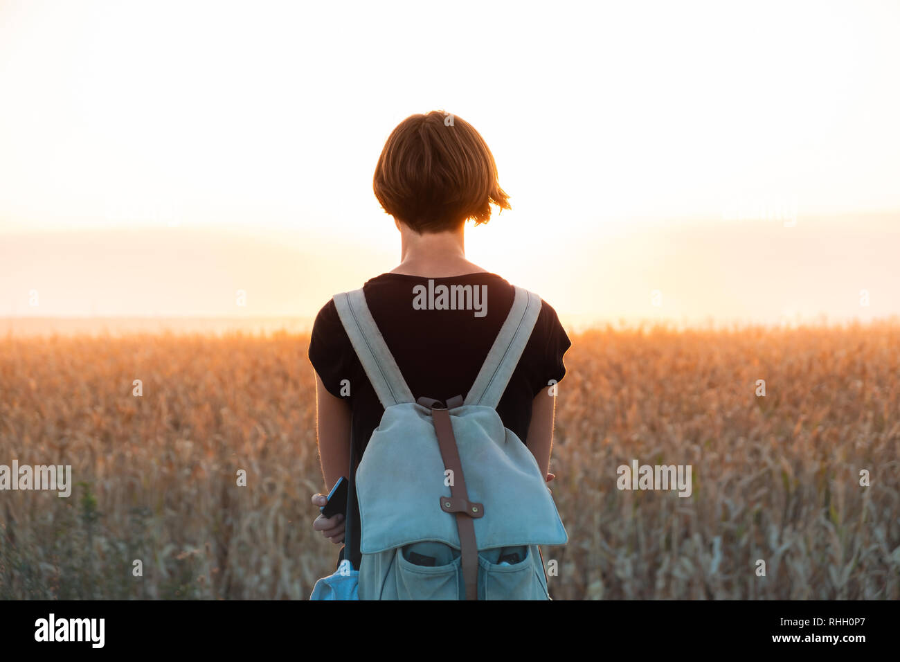 Backlit figure of a woman enjoying bright sunset. Female person ...