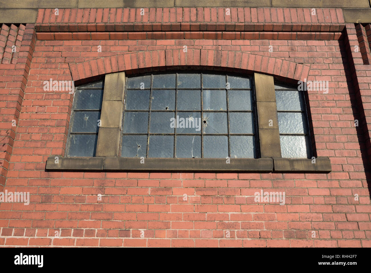 Red brick wall on industrial building, with arched window and stone ...