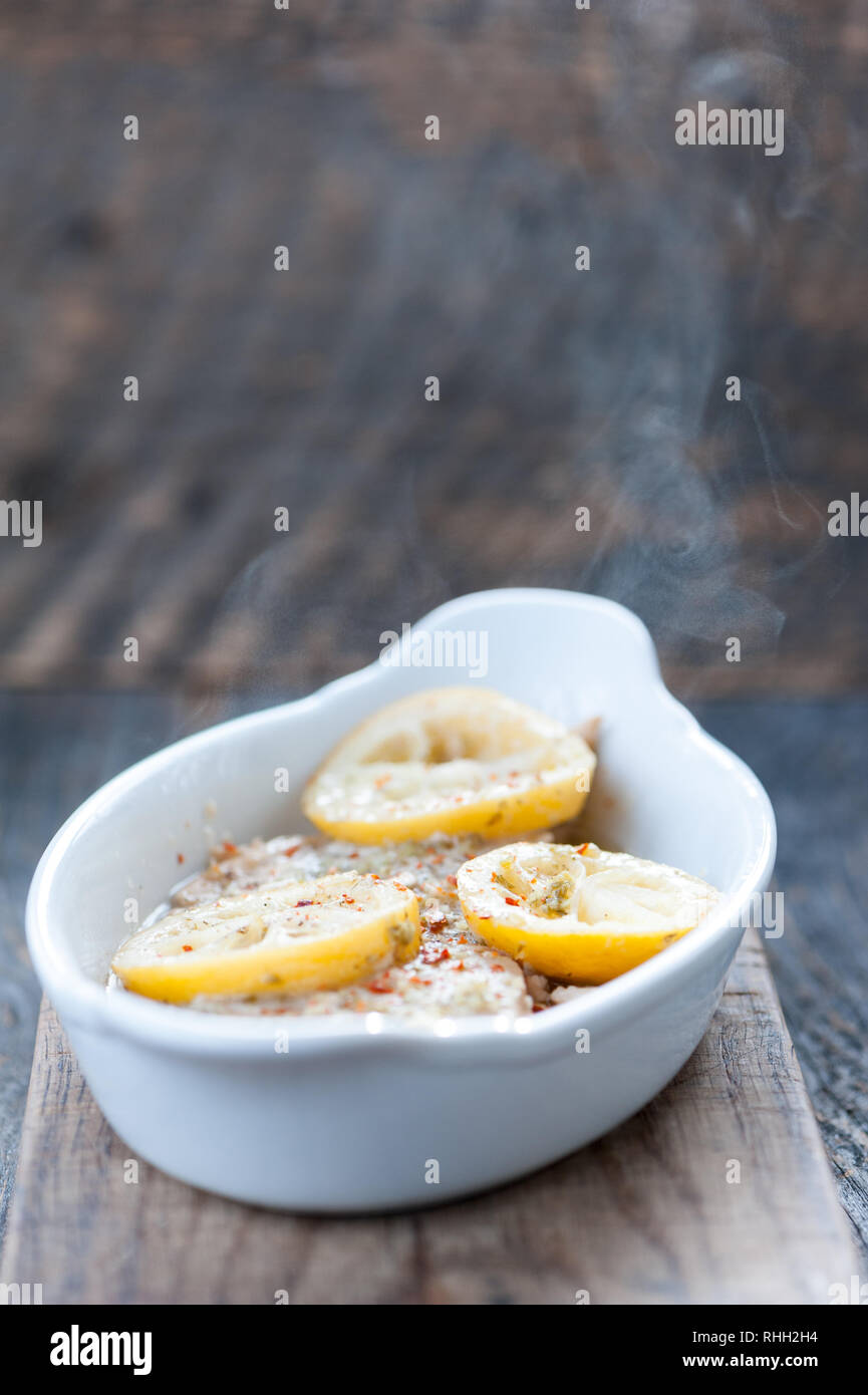 Baked fish fillet in butter and lemon sauce Stock Photo - Alamy