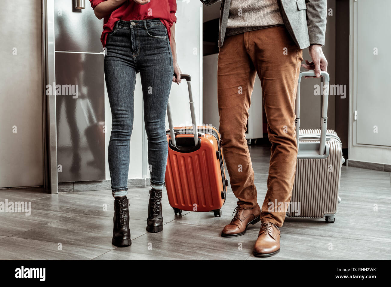 Two stylish partners holding their modern suitcases Stock Photo - Alamy