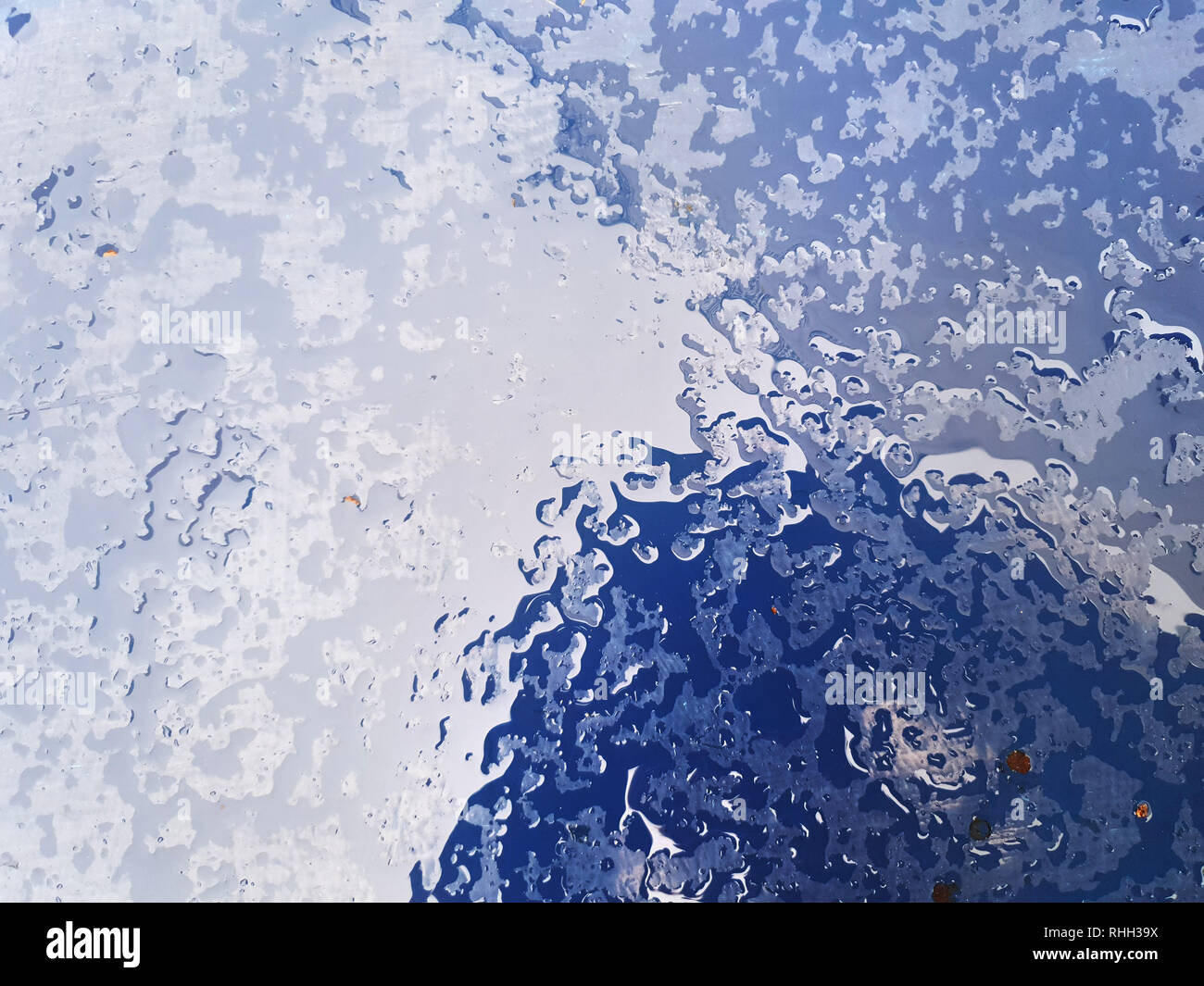 Puddle of blue water, reflections of the sky of different degrees of ...