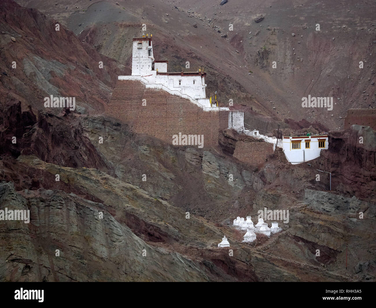 White buildings Buddhist monastery of Basgo among maroon mountains ...
