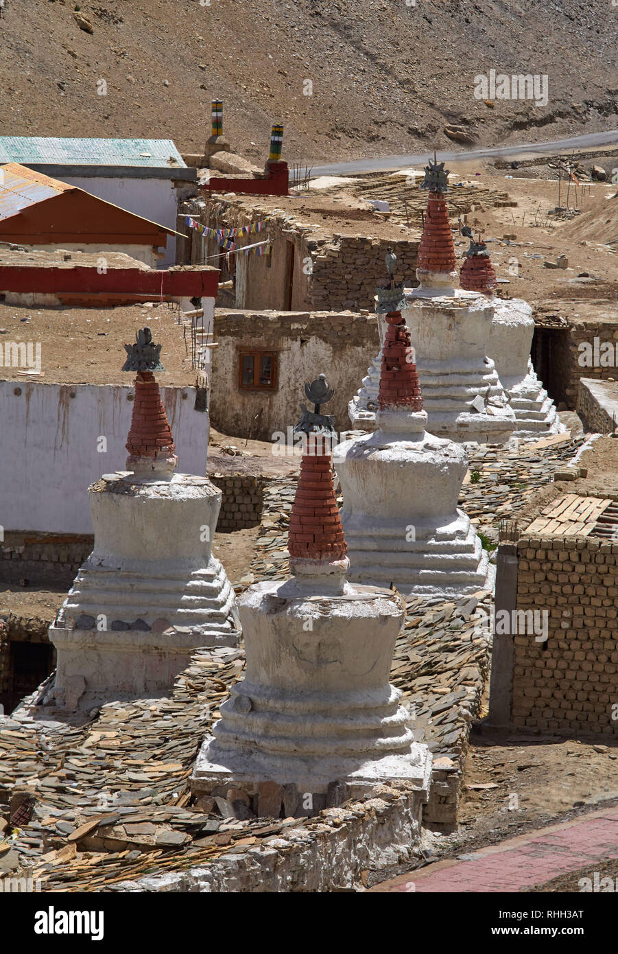 White Buddhist stupas, chortens with red tops, made of white stone ...
