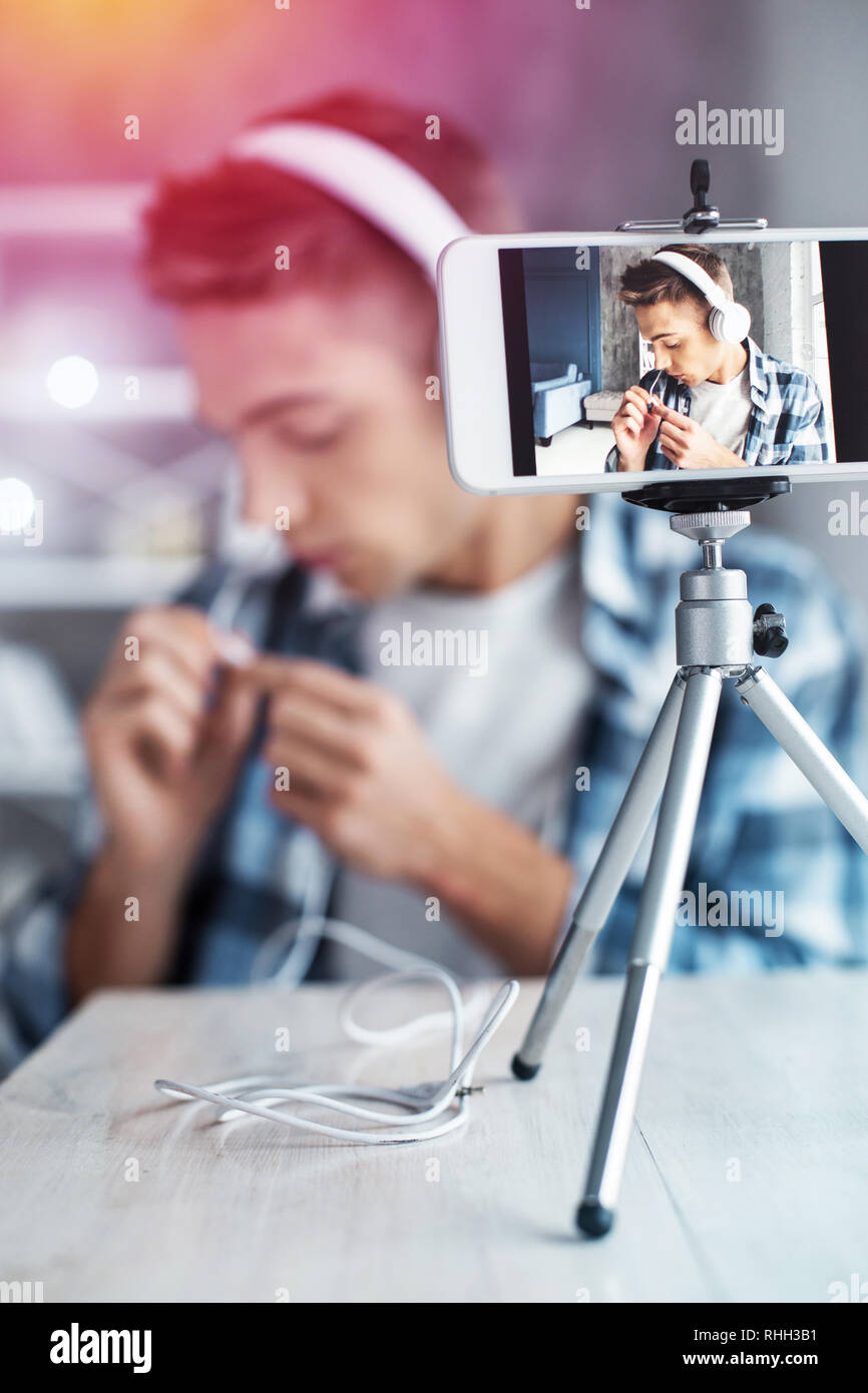 Young famous blogger making video using earphones and photo stand Stock ...