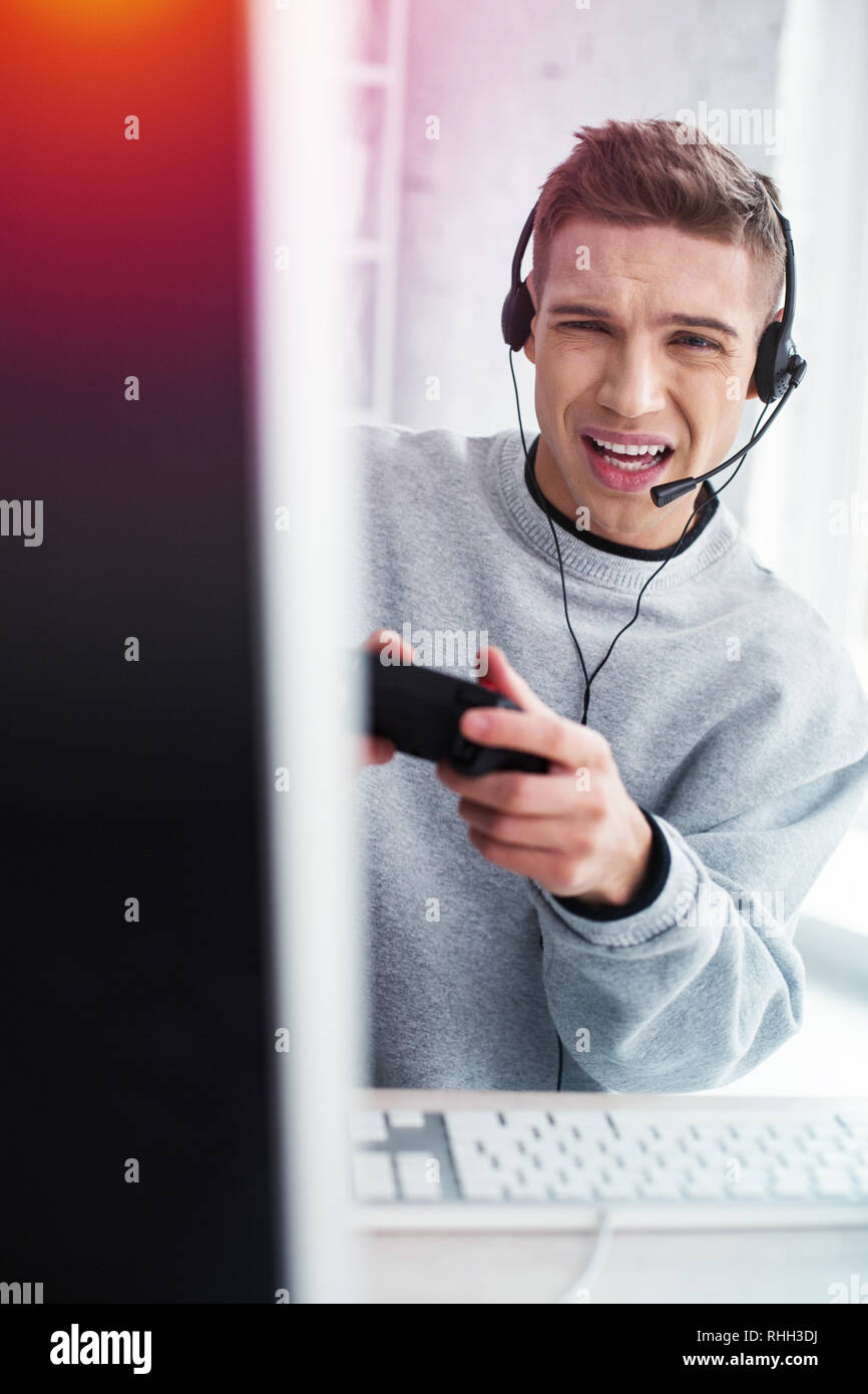 Emotional handsome young man feeling curious while losing video game ...