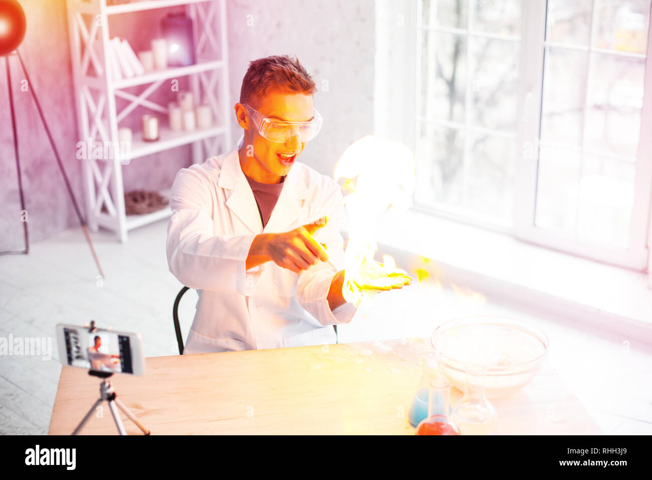 Student wearing white lab coat making experiment with fire in front of ...