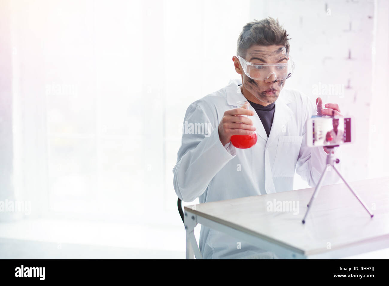 Video blogger making chemistry experiment having dirty face after ...