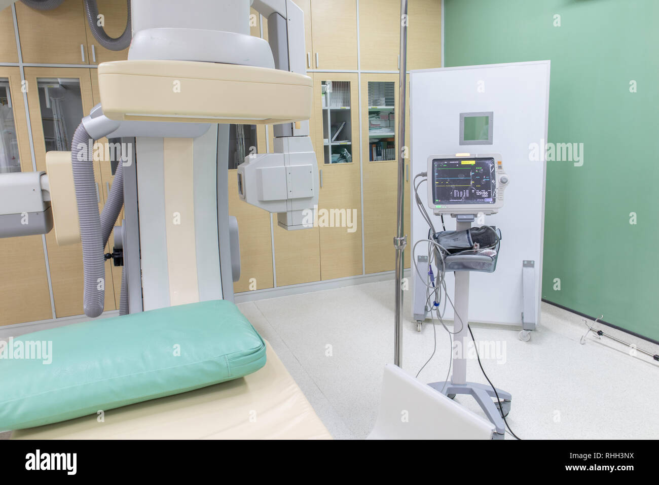 Vital signs monitor and large C-arm angiograph, operating room with X ...