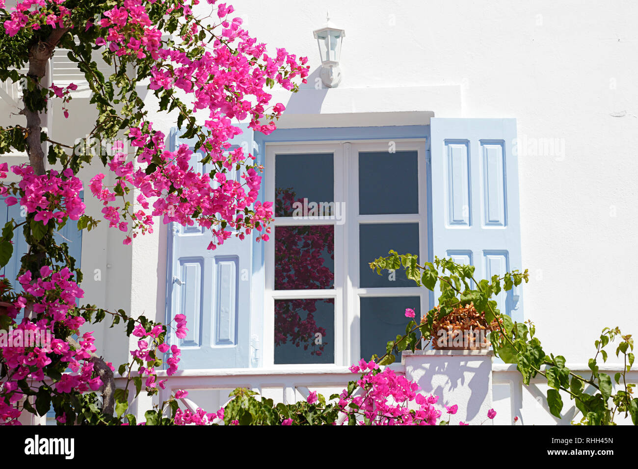 Window with blue wooden shutters in a white whitewashed facade, Oia ...