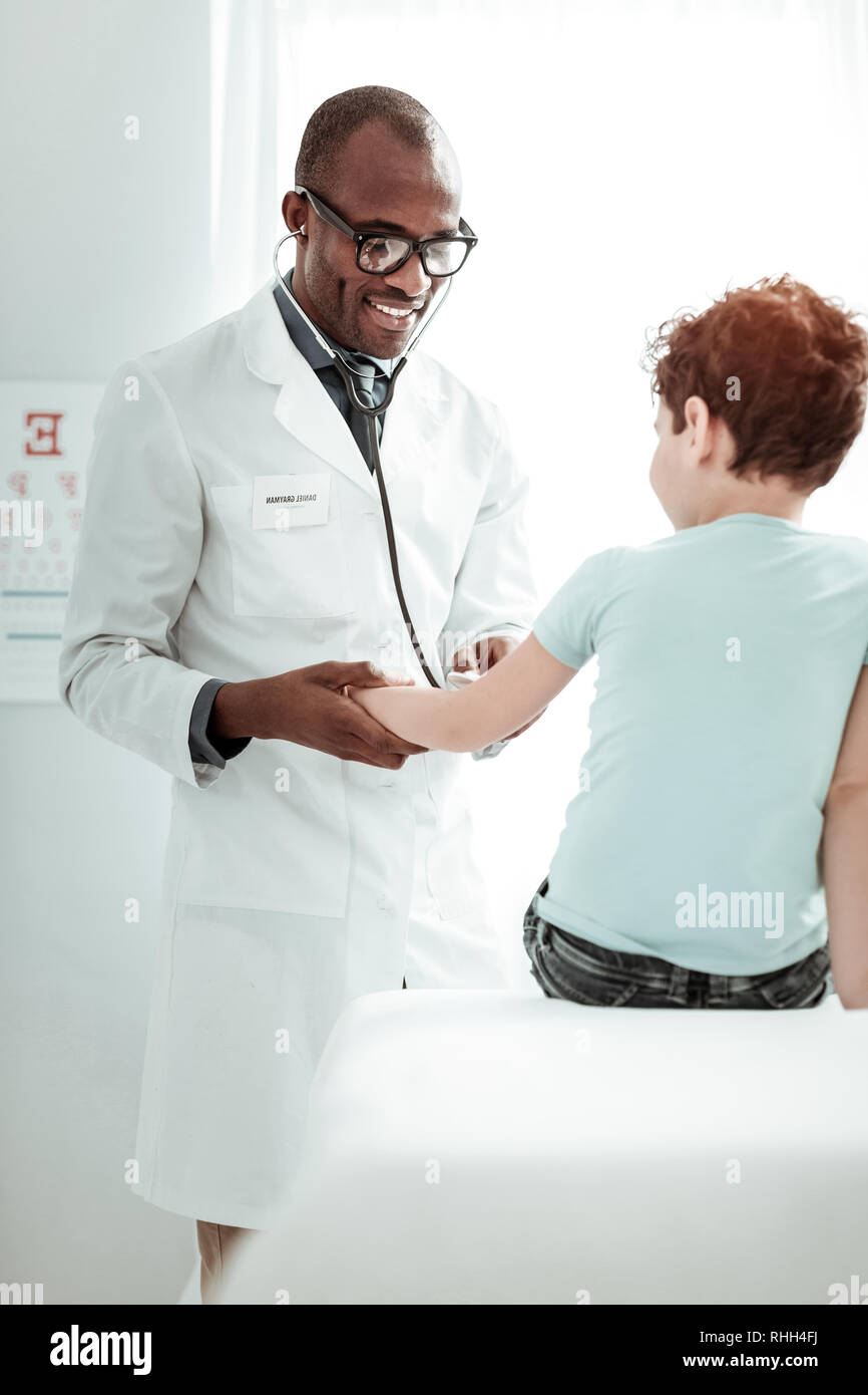 Kind dark-skinned doctor working in children hospital Stock Photo - Alamy