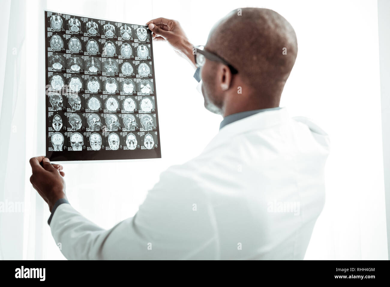 Attentive dark-skinned practitioner taking decision for diagnosis Stock ...