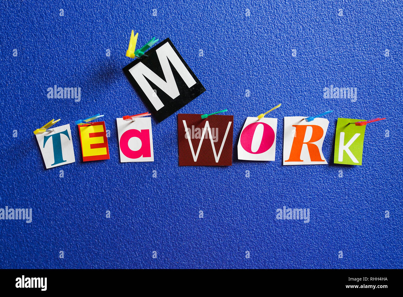 Teamwork letters cut from magazine pinned on blue background Stock ...
