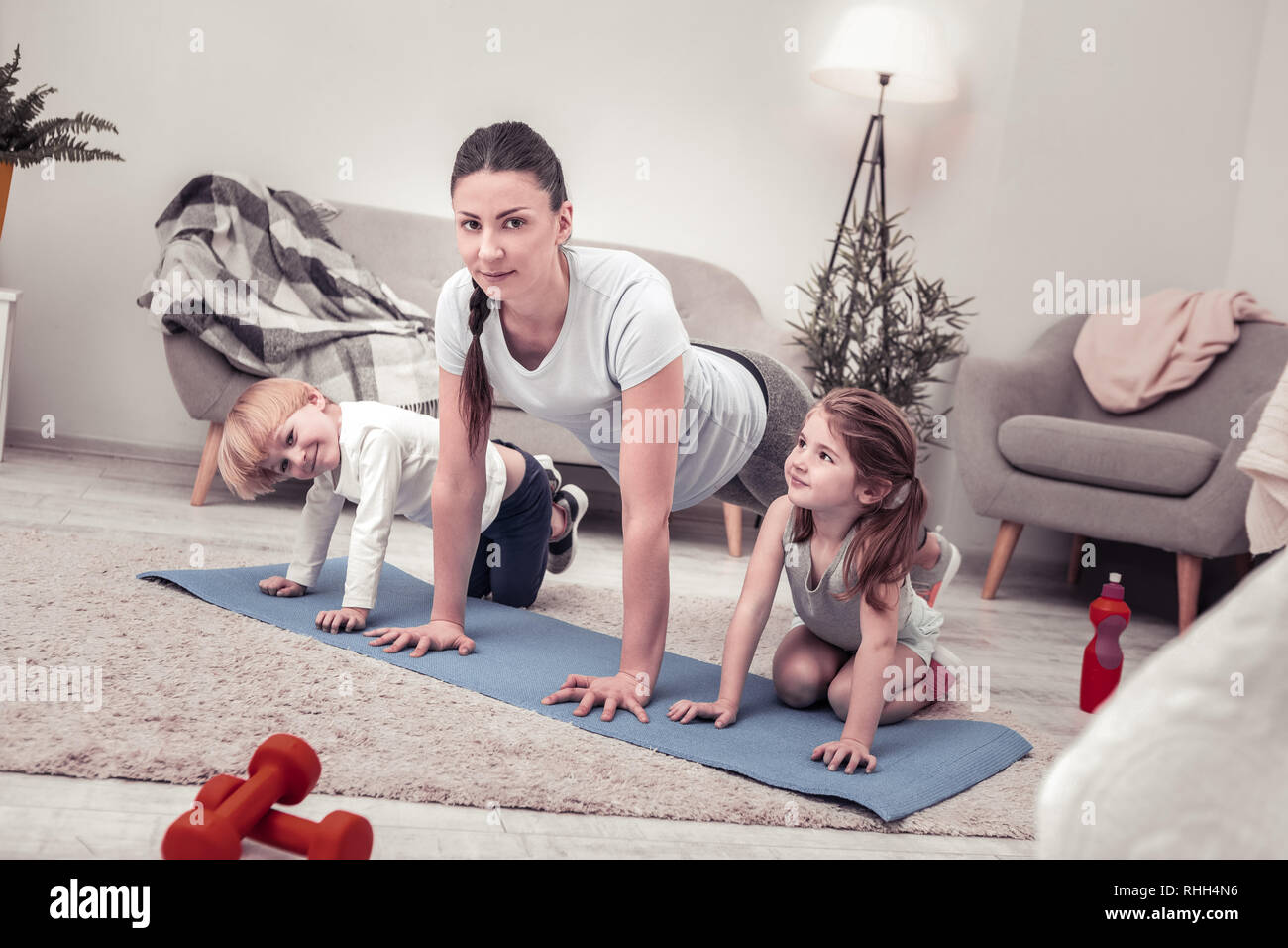 Children learning to do push-ups with their mother Stock Photo - Alamy