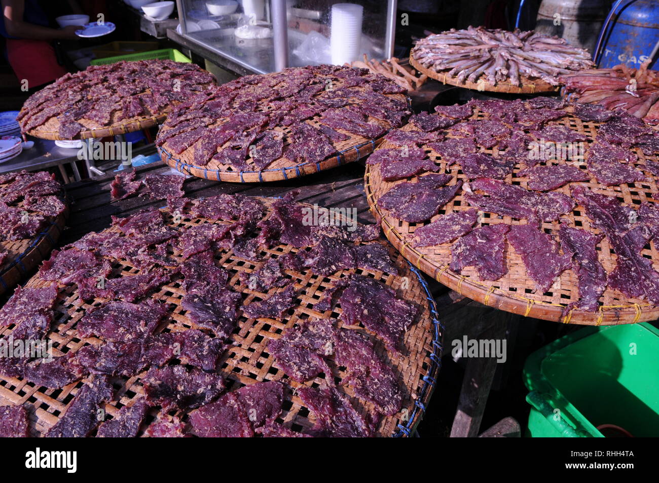 Red meat & fish drying in the sun on rattan trays, at a local ...
