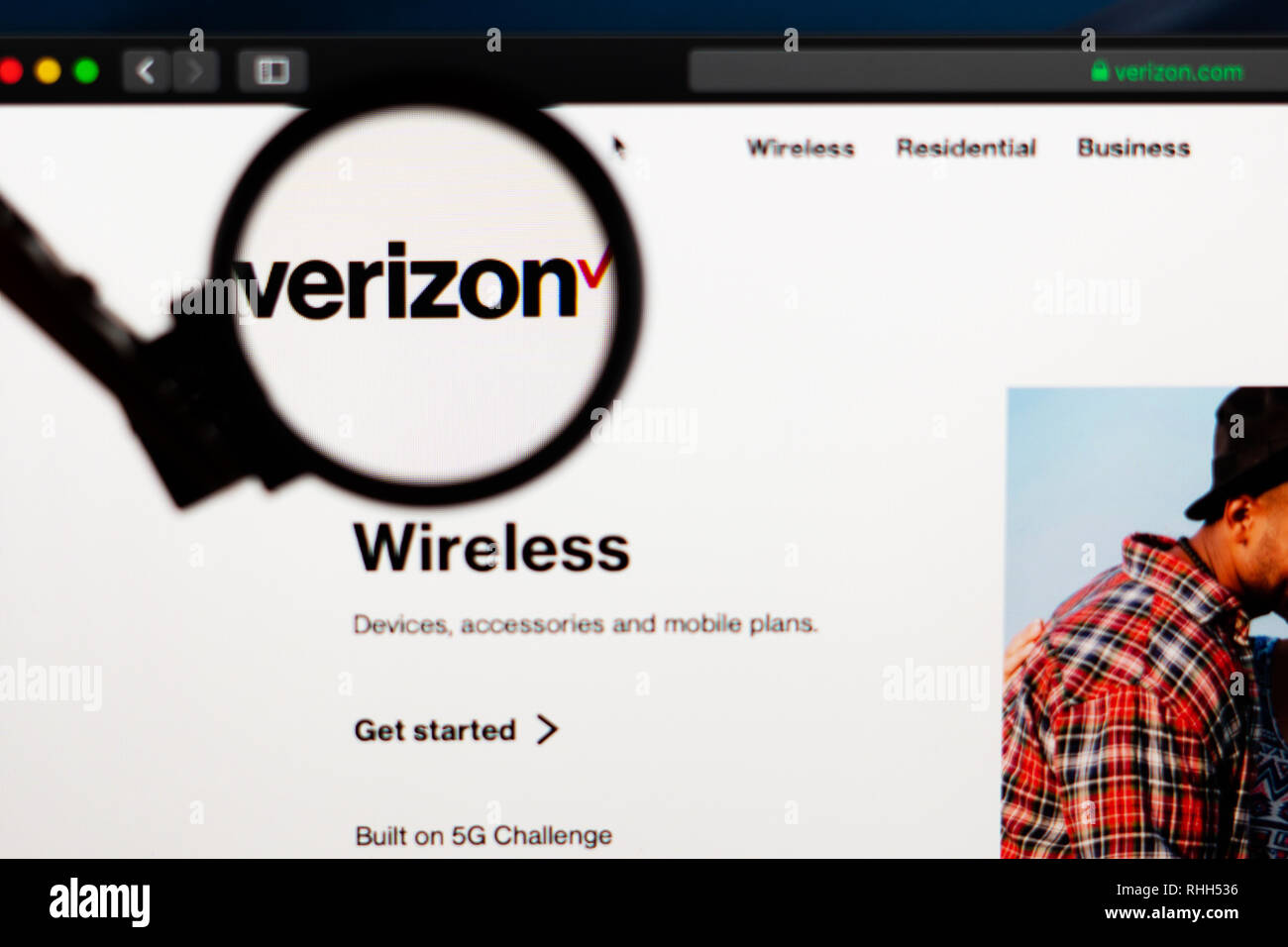 Verizon website homepage. Verizon logo visible through a magnifying ...