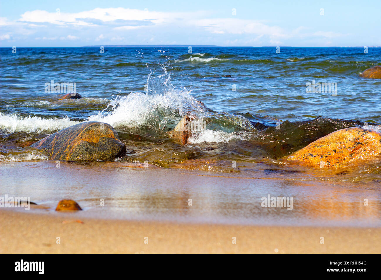 Splitting the sea wave on the stone shore Stock Photo - Alamy
