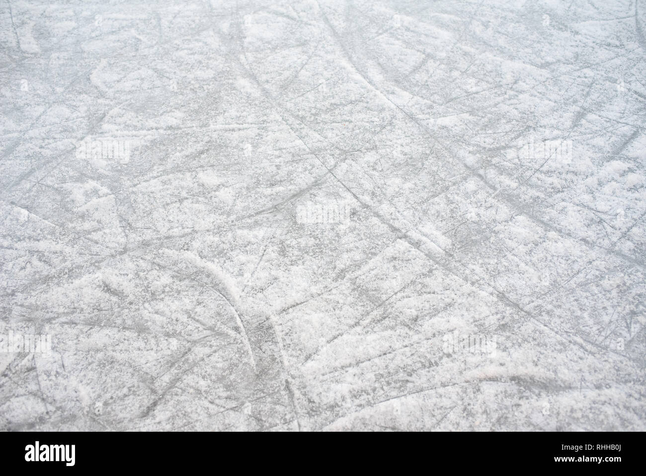 Floor background of a frozen ice rink with skate marks, with white snow ...
