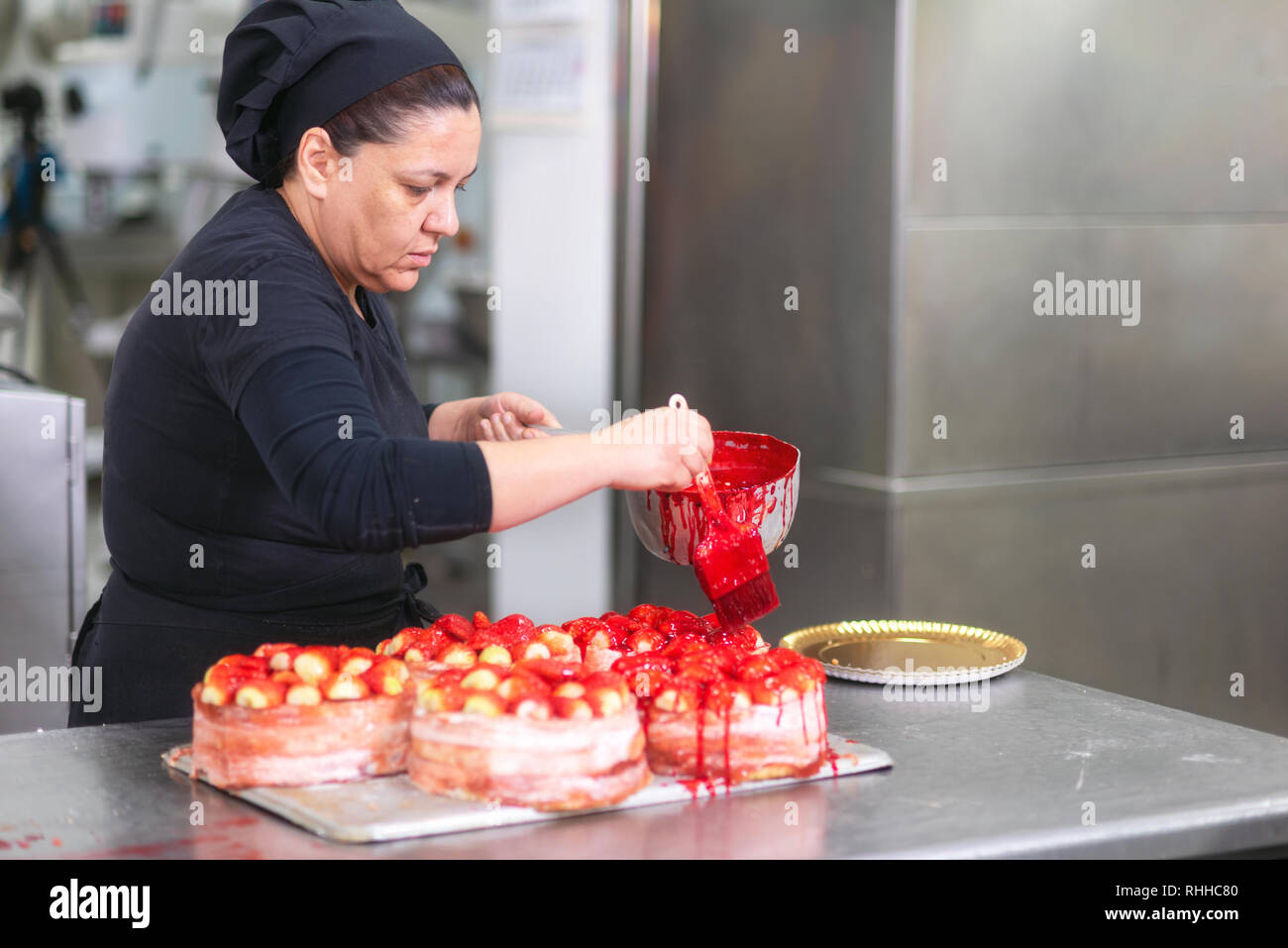Pastry Chef making a delicious strawberry cake in pastry shop kitchen ...