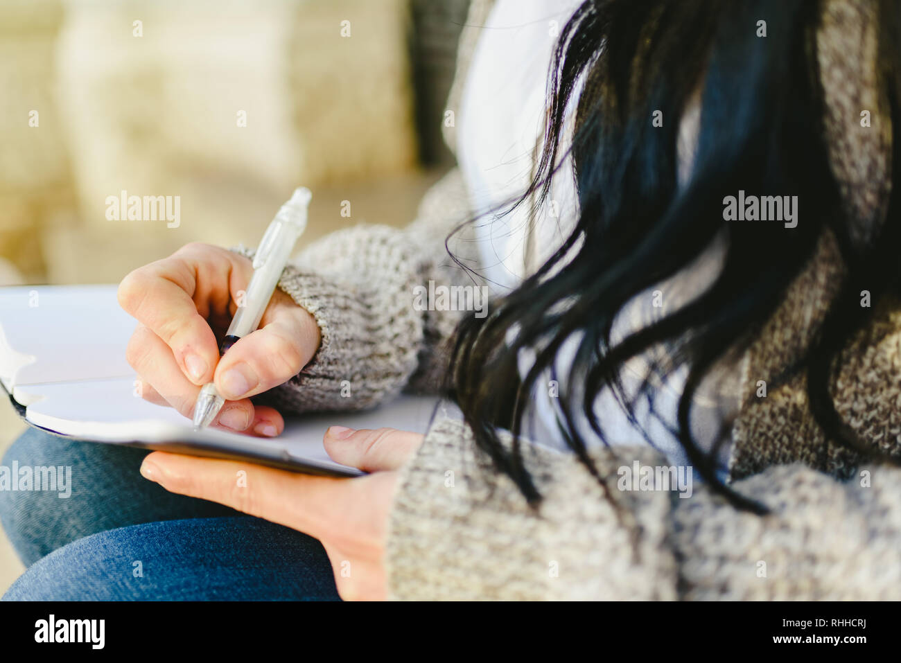 Woman's hand taking notes in her notebook with pen, sitting Stock Photo ...