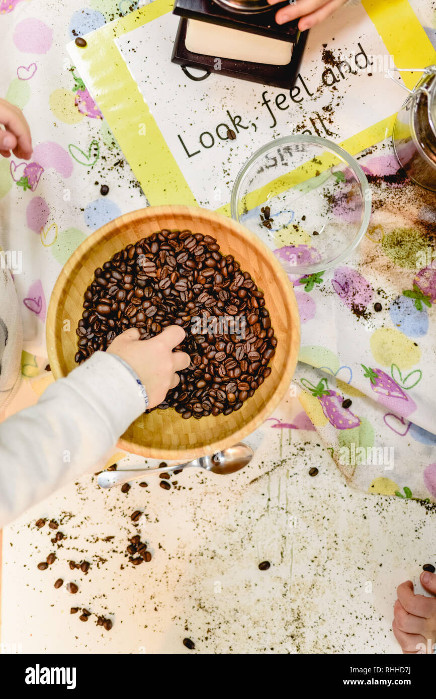 Child experiencing texture and learning by touching coffee beans Stock ...