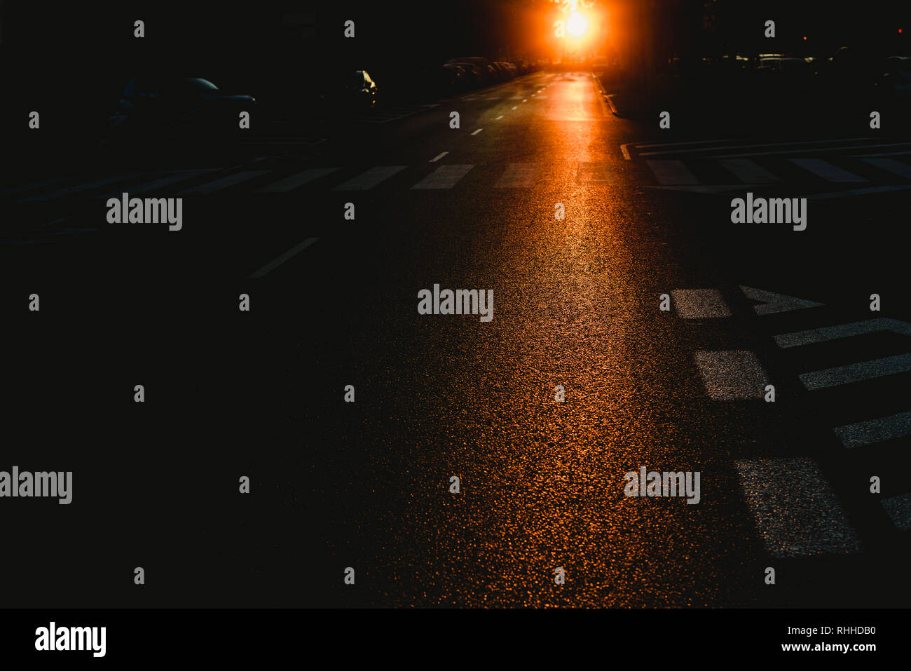 Urban background of a dark street at dusk with cars and traffic marks ...