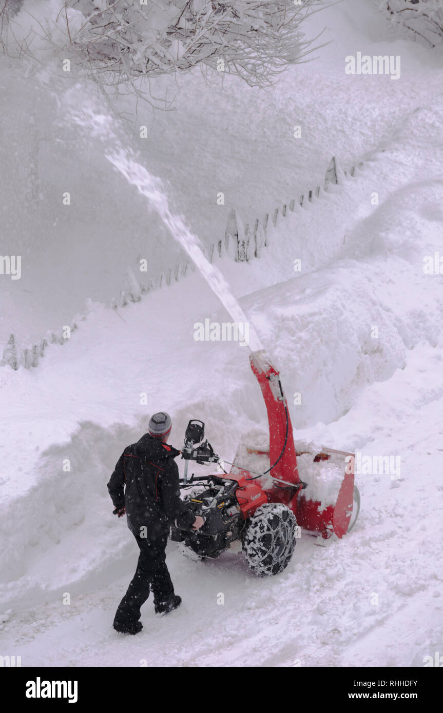 man takes off the snow with a snow plow, high snow on the sides Stock ...