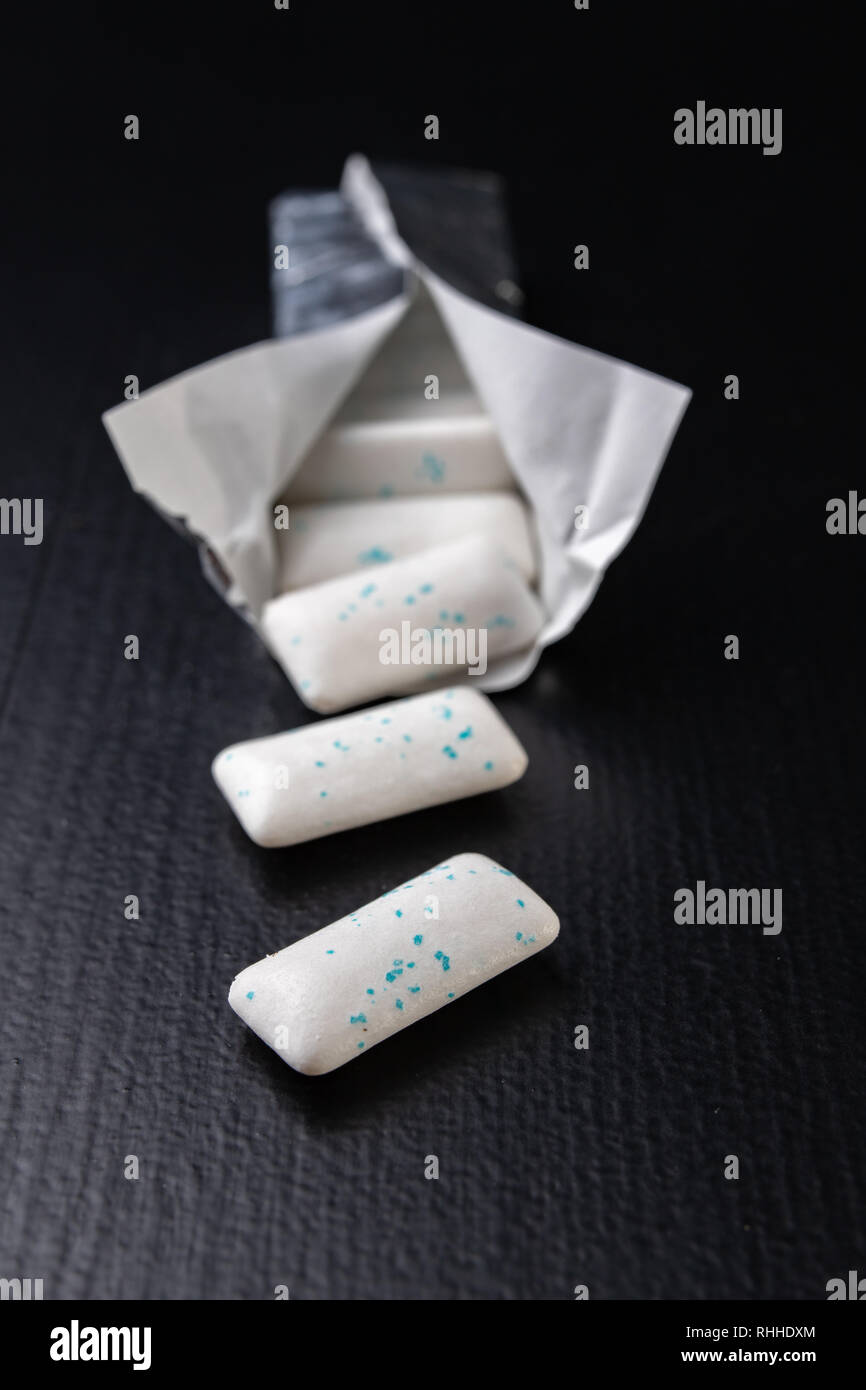 Chewing gum on the table. Mint refreshing tablet in a silver package ...