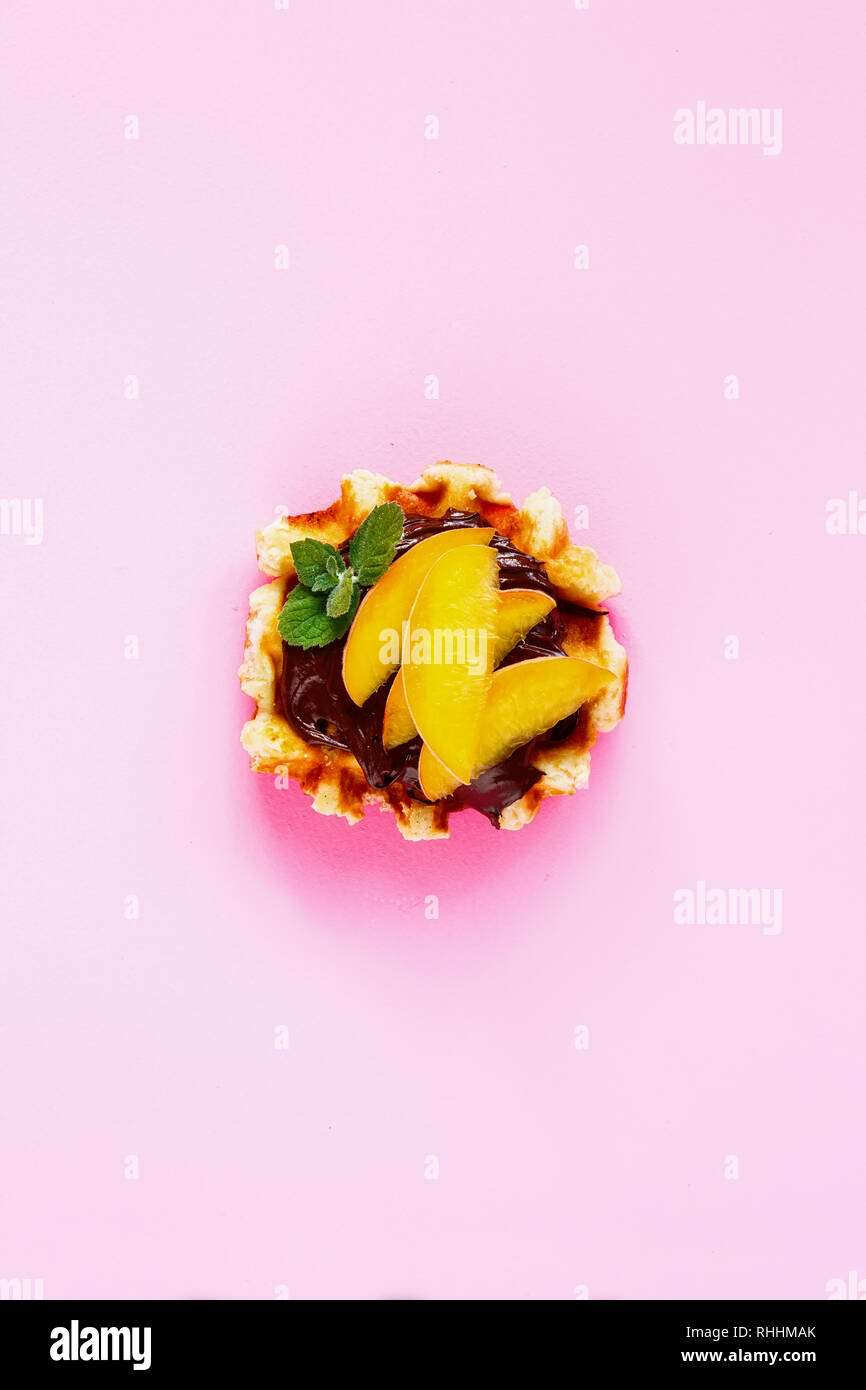 Flat lay of waffle with chocolate and peach on pink background Stock ...