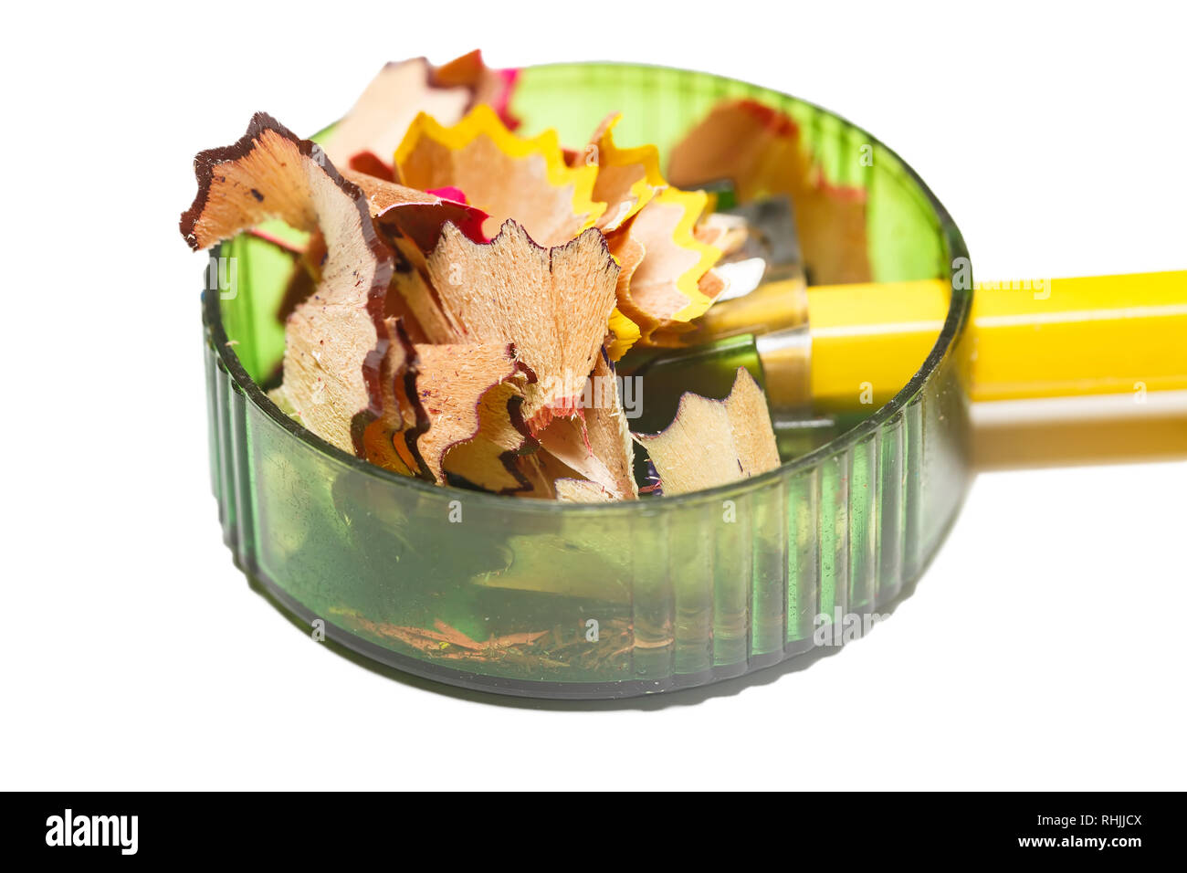 Pencil sharpener with color shavings on a white background. Side view ...