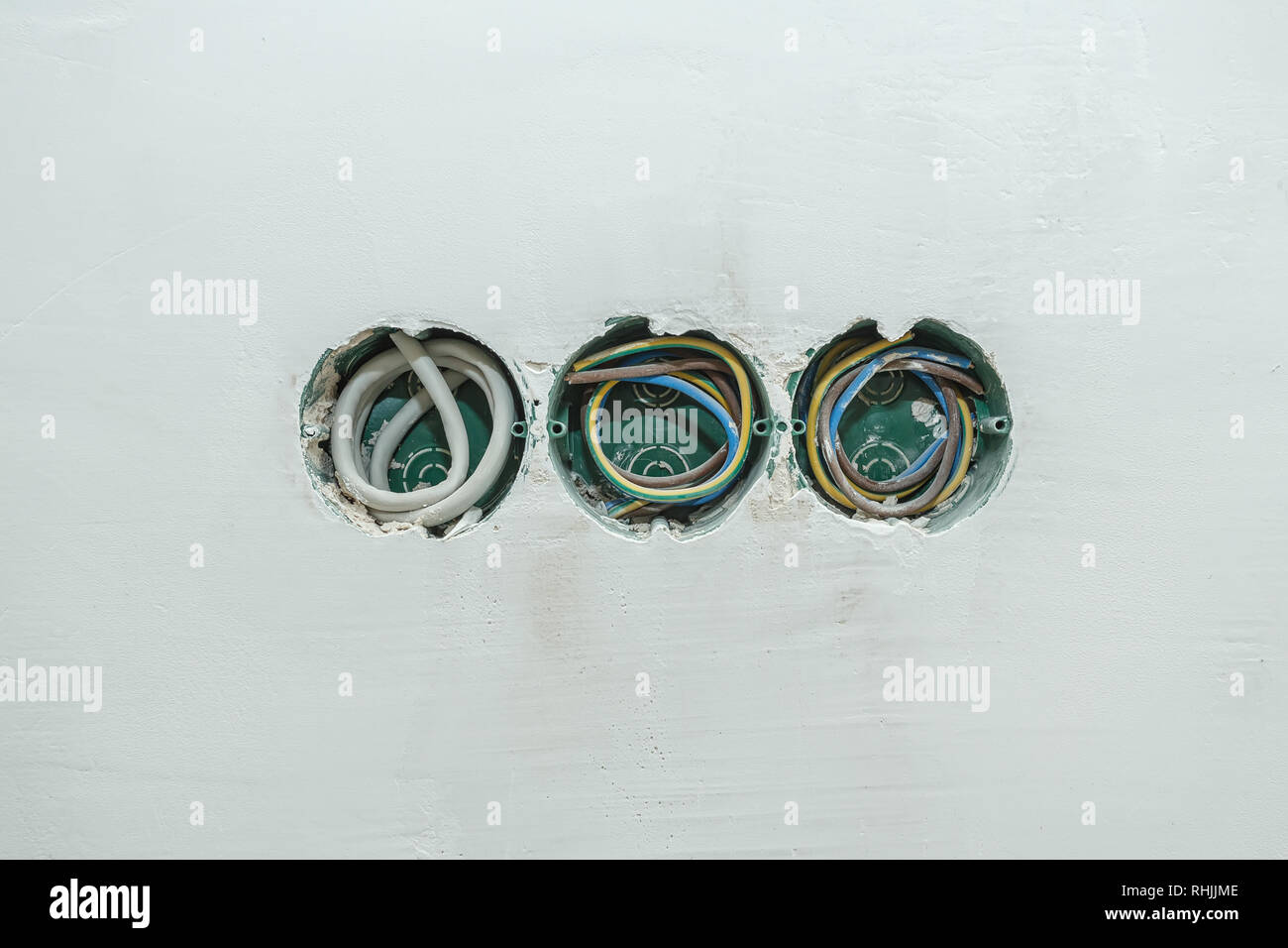 Three boxes under the electrical outlet with wires Stock Photo - Alamy