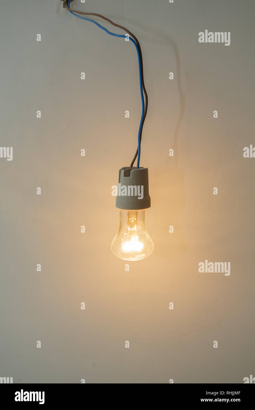 Light bulb turned on hanging on a long wire Stock Photo - Alamy