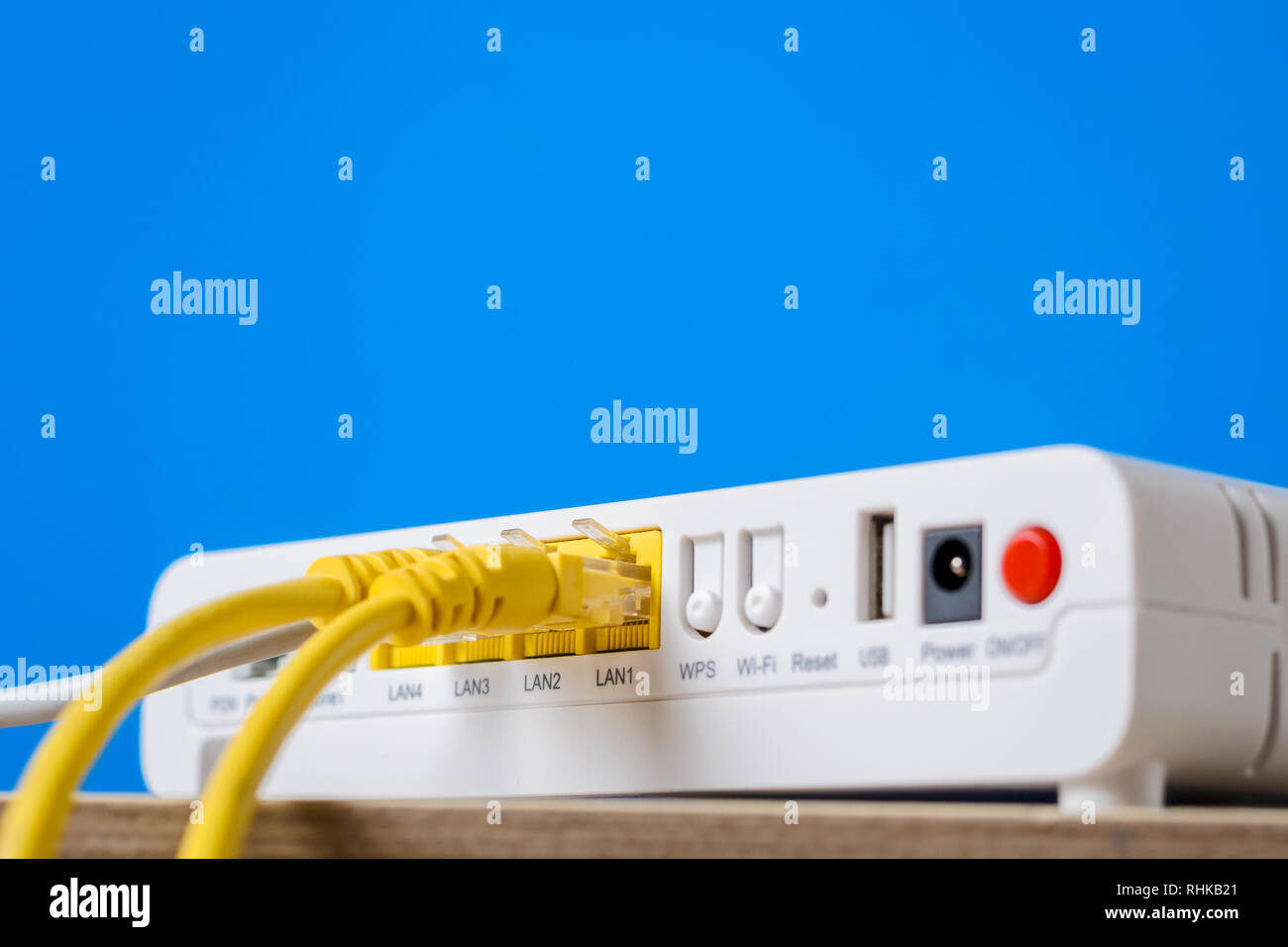 wireless internet router with connecting cables on blue background ...