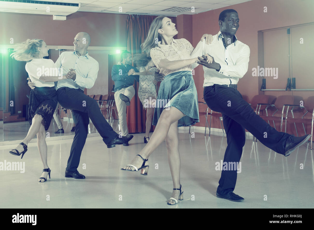 Portrait of young positive people practicing vigorous jive movements in ...
