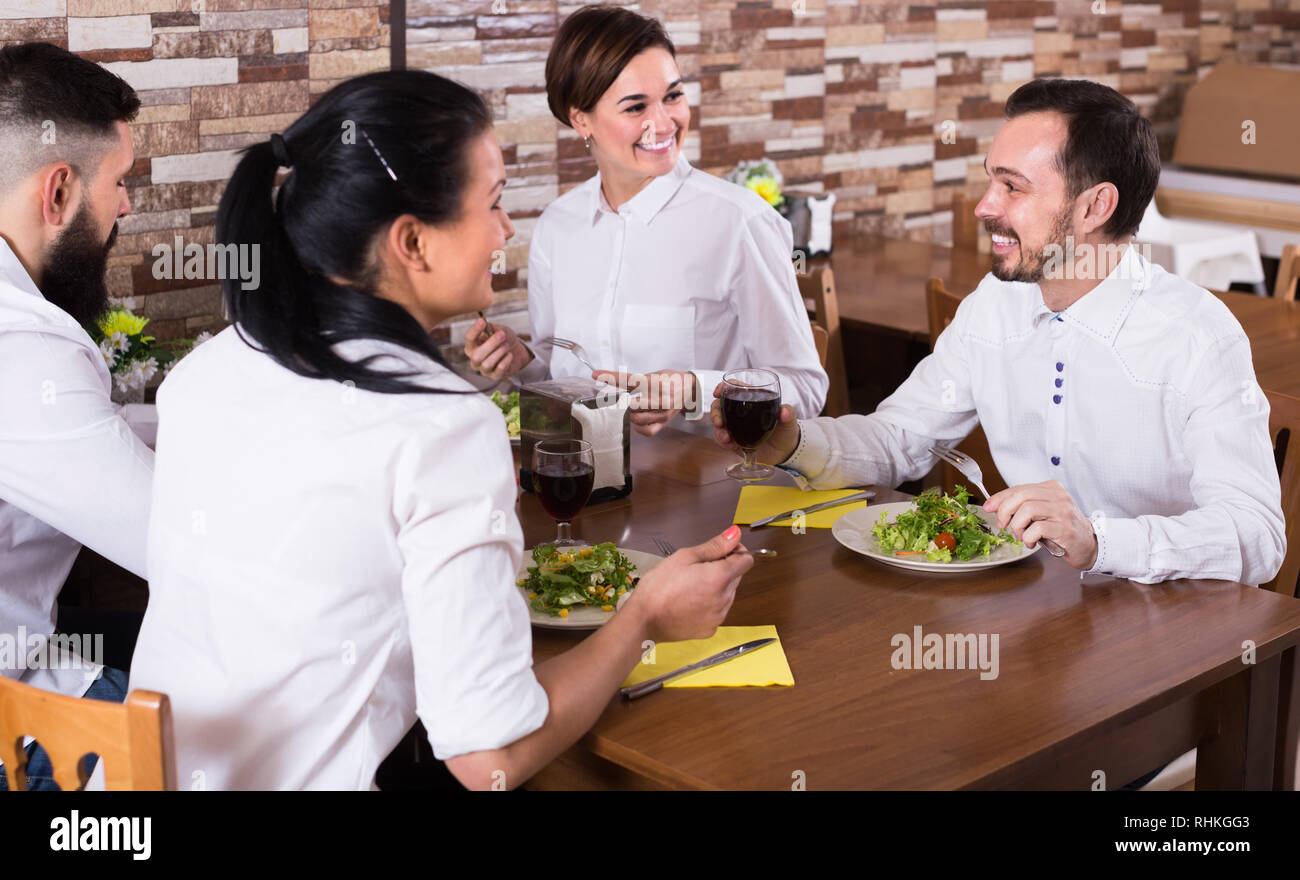 group of young friends eating at restaurant table and chatting Stock ...