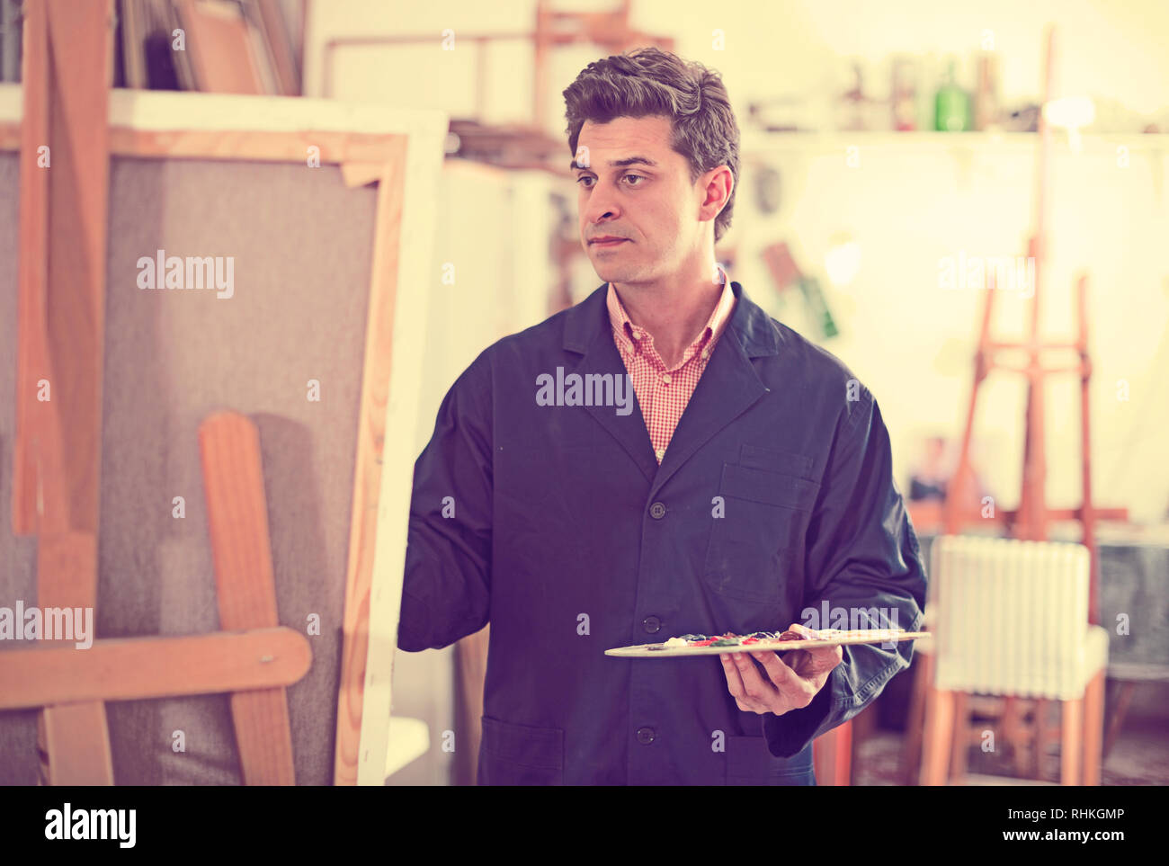 Happy art painter holding artist palette and painting on canvas Stock ...