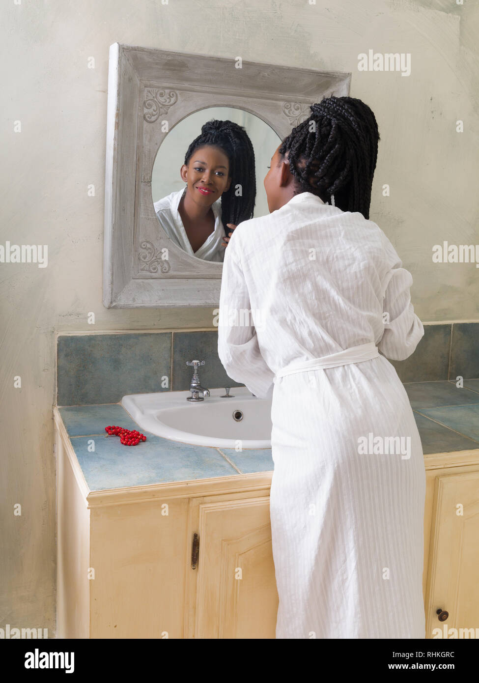 African american woman checking hair in mirror hi-res stock photography ...