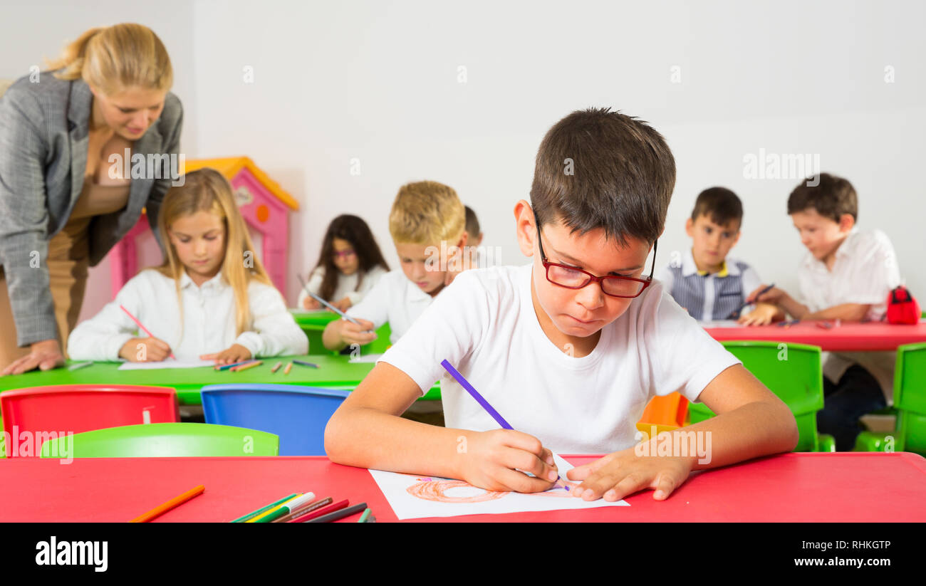 Little diligent schoolboy drawing at lesson in elementary school Stock ...