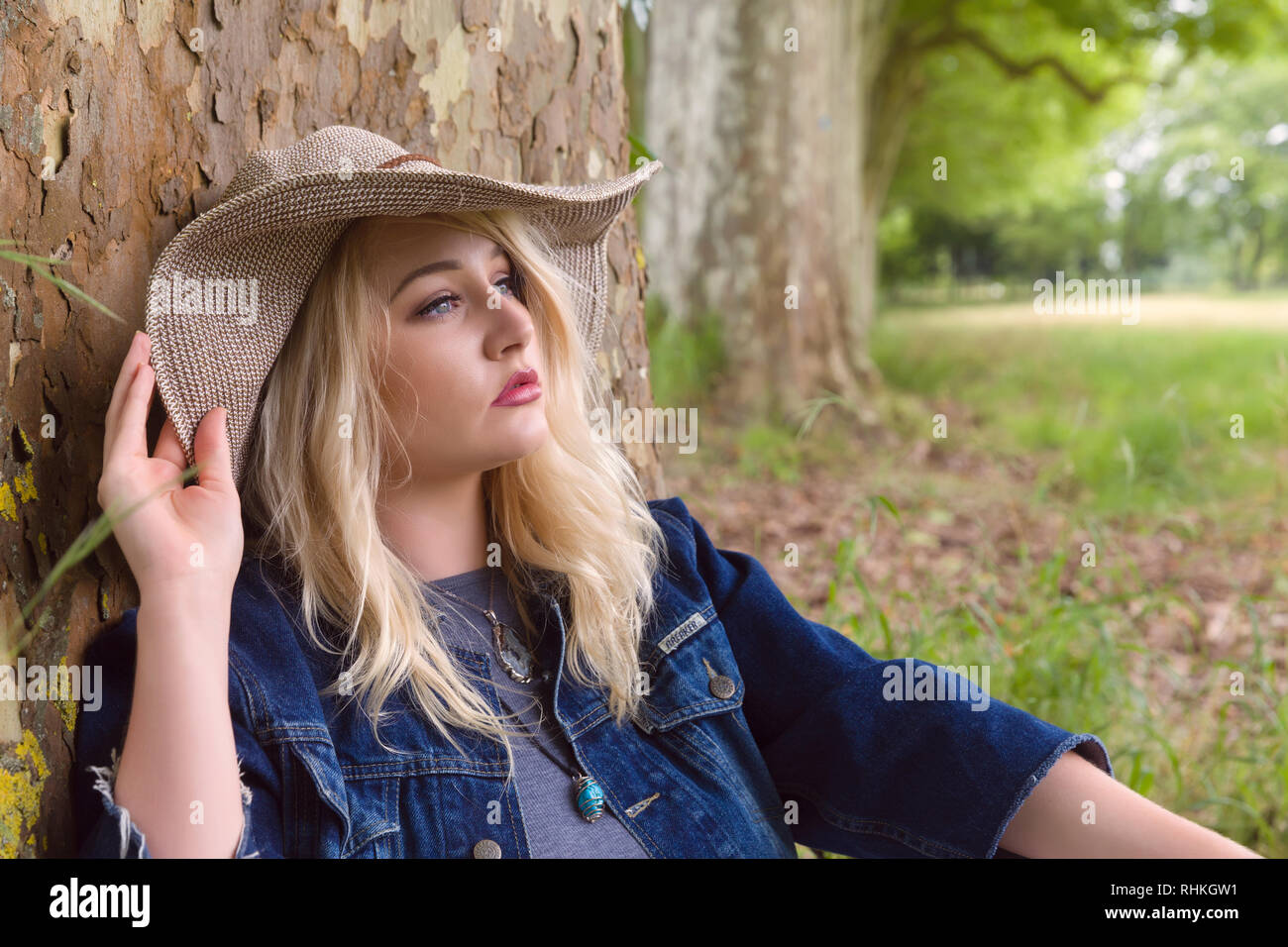 Woman sitting against tree trunk hi-res stock photography and images ...