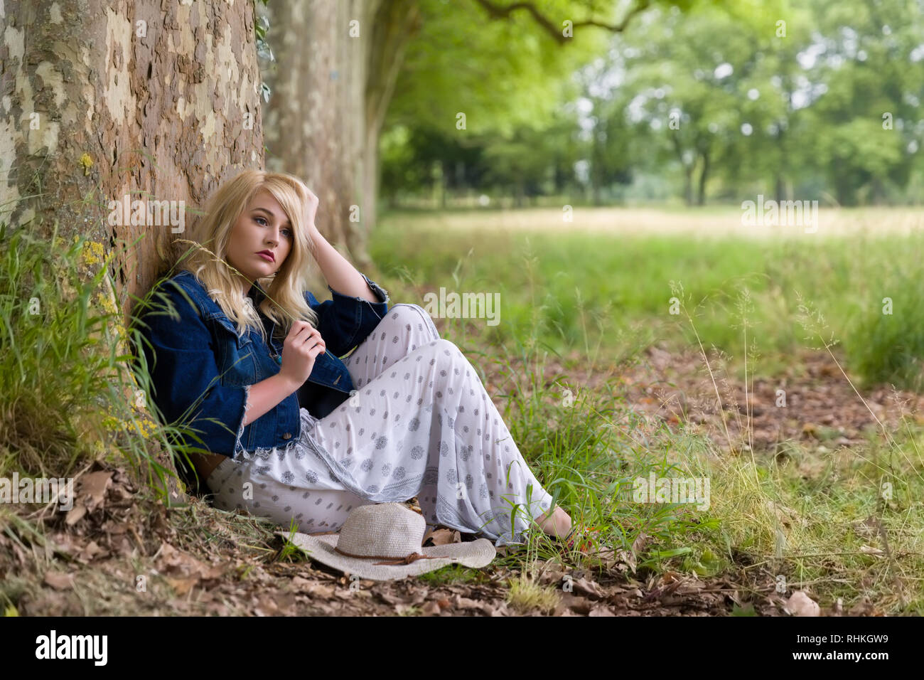 Woman sitting against tree trunk hi-res stock photography and images ...