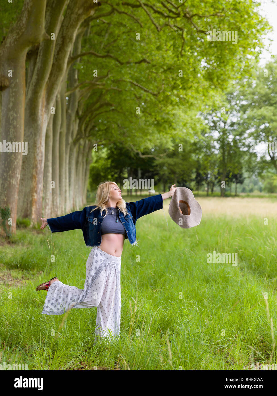 Beautiful young blonde woman dancing in the countryside in summertime ...