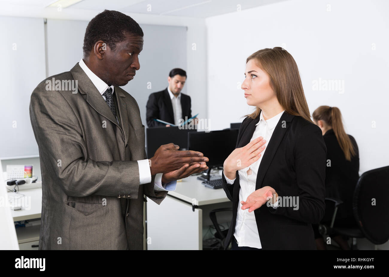 Irritated boss scolding female subordinate in modern office, pointing ...