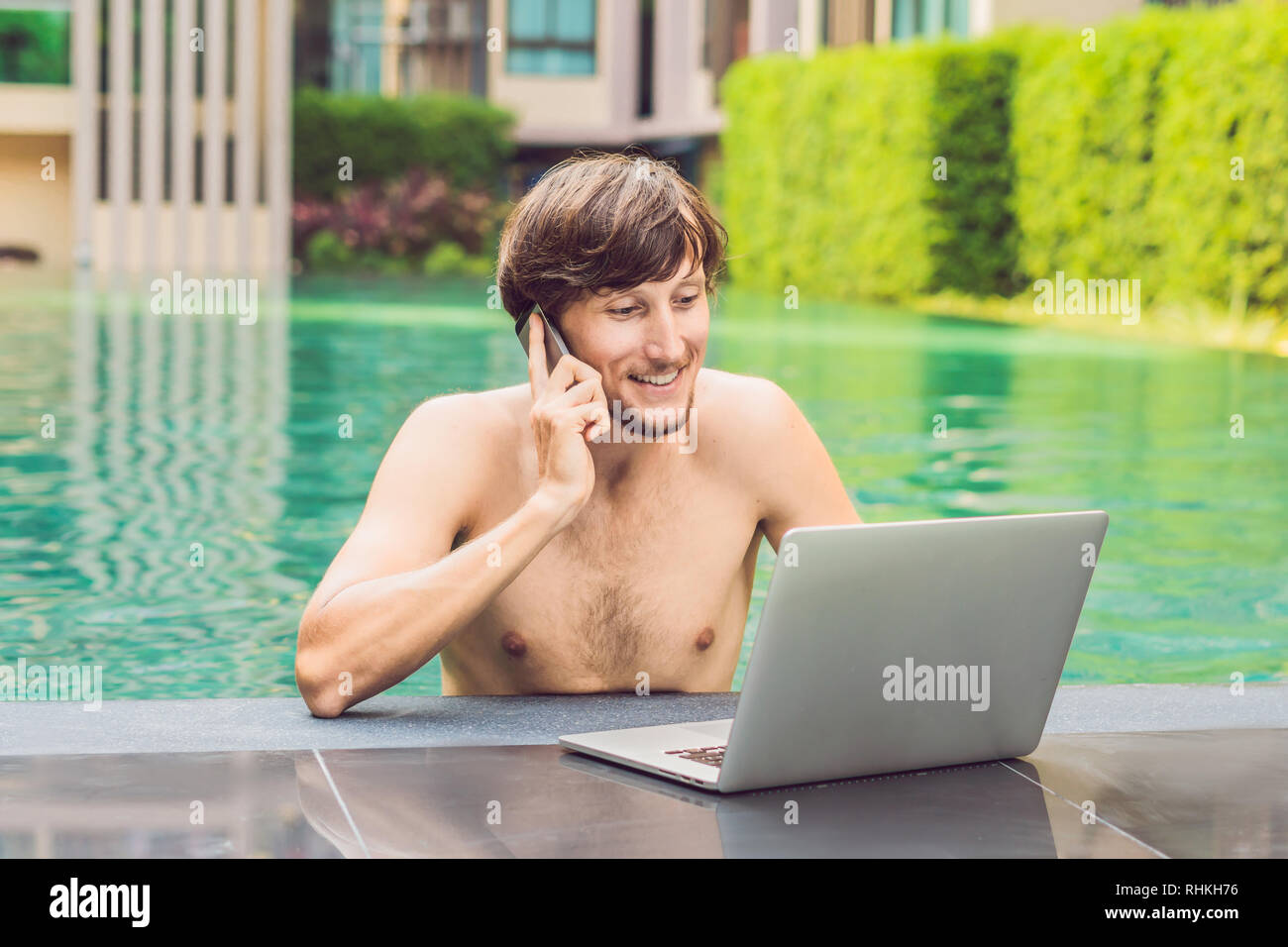 Young freelancer working on vacation next to the swimming pool Stock ...