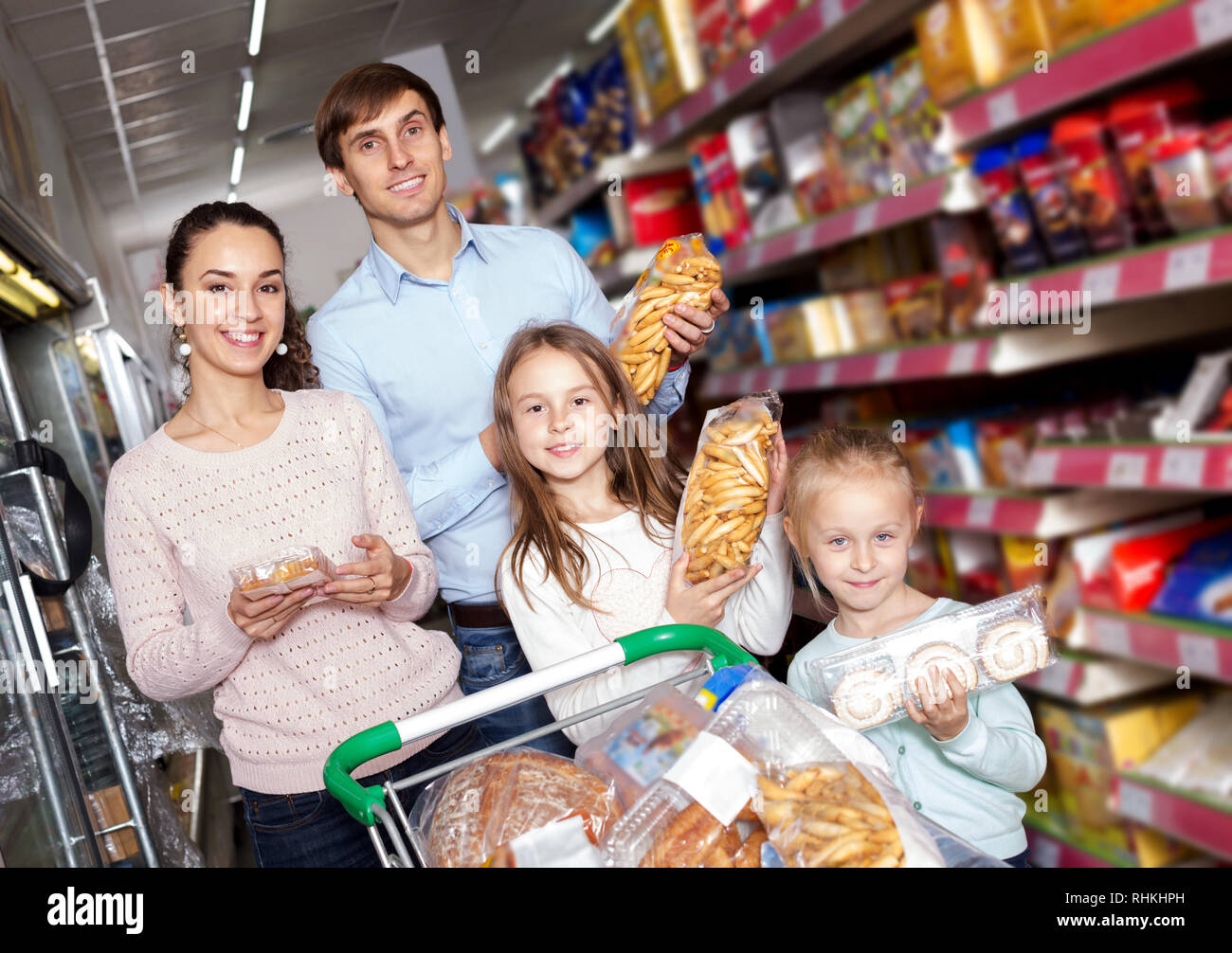Beautiful customers with small children purchasing shortcakes in ...