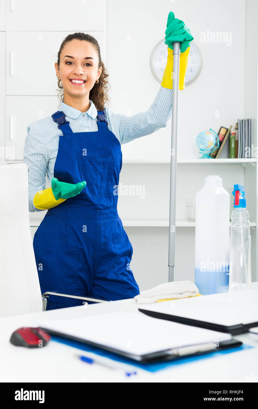cheerful smiling female professional cleaner dusting in modern office ...