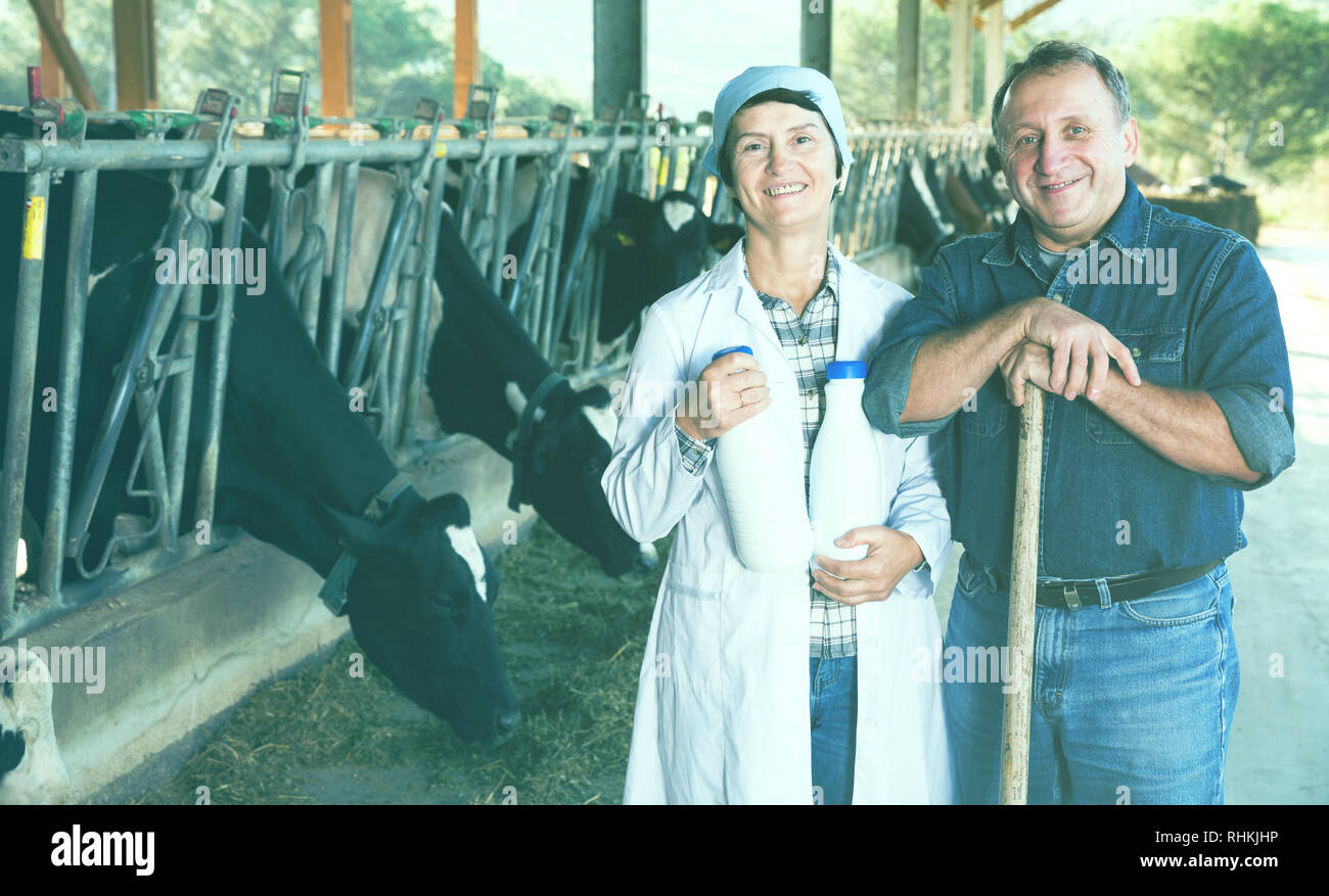 Smiling male and female workers posing on cow farm Stock Photo - Alamy