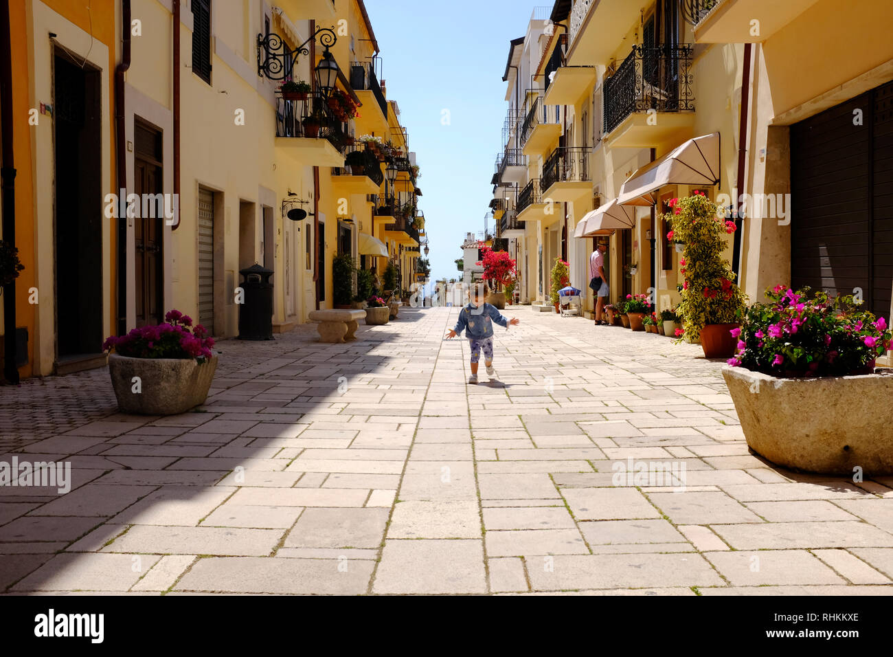 A little girl runs happily in the picturesque Italian village. San ...