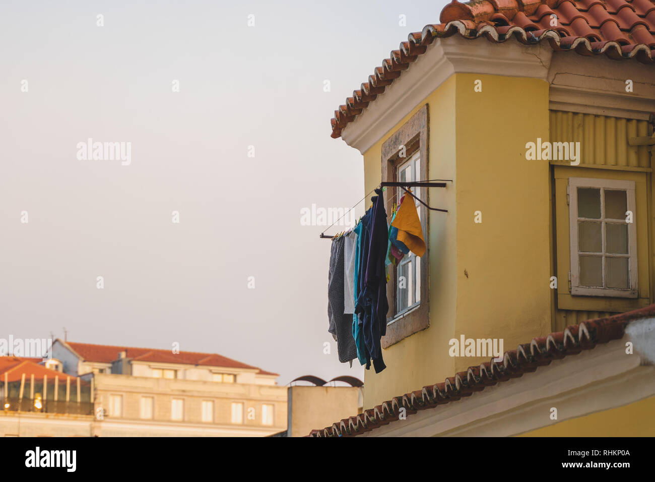 Colorful clothes drying hanging outside attic window, old traditional ...