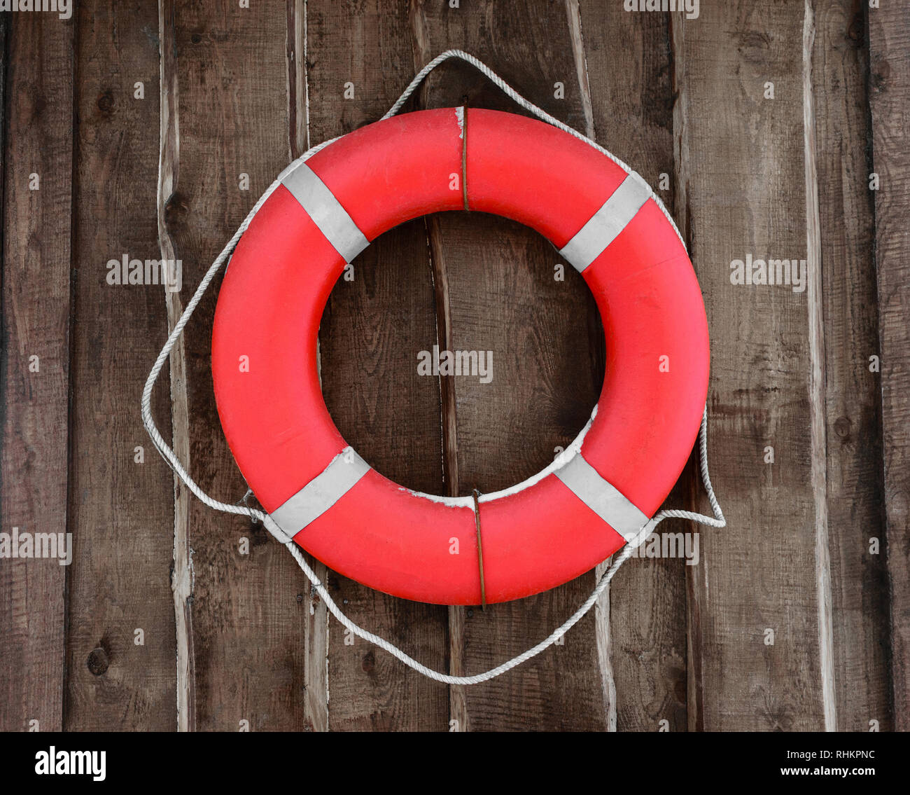 Red and round lifebuoy hanging on brown wooden wall. Part of lifebuoy ...