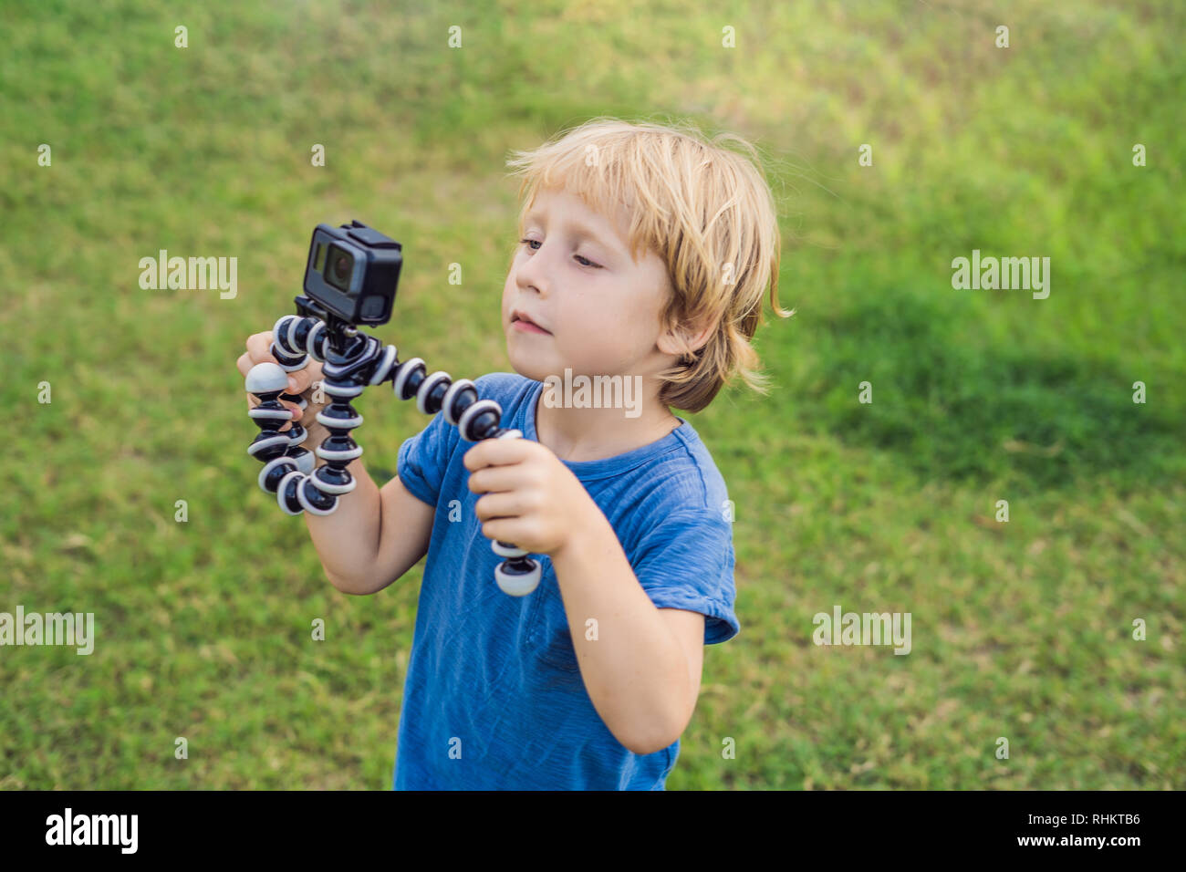 Little boy shoots a video on an action camera against a background of ...