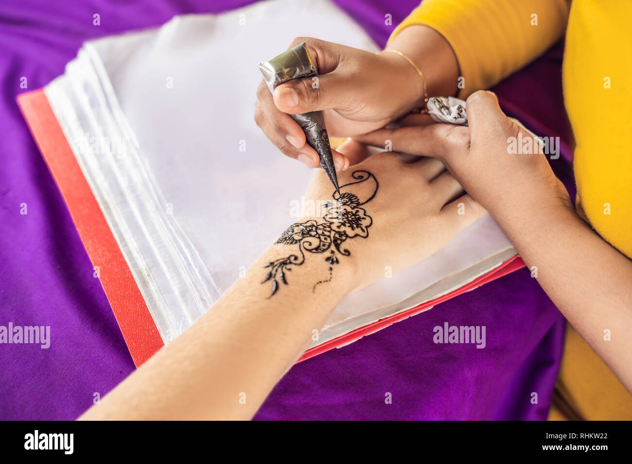 Woman is drawing on hand. Draw on the hand Indian mehendi picture Stock ...